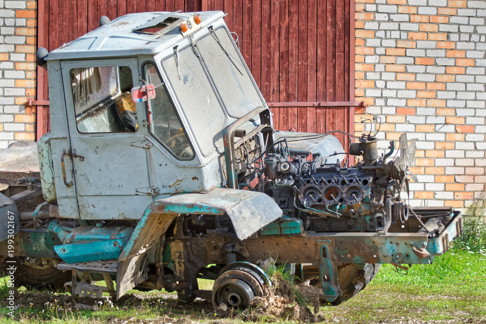 Old disassembled tractor with removed engine compartment hood and ...