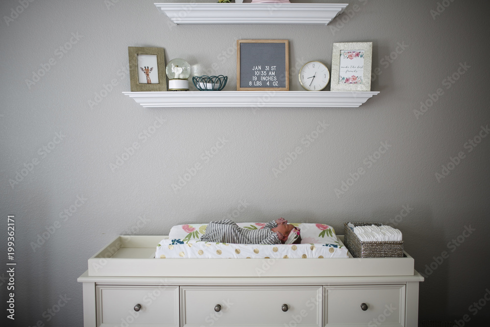 Newborn baby girl lying on changing table Stock Photo | Adobe Stock