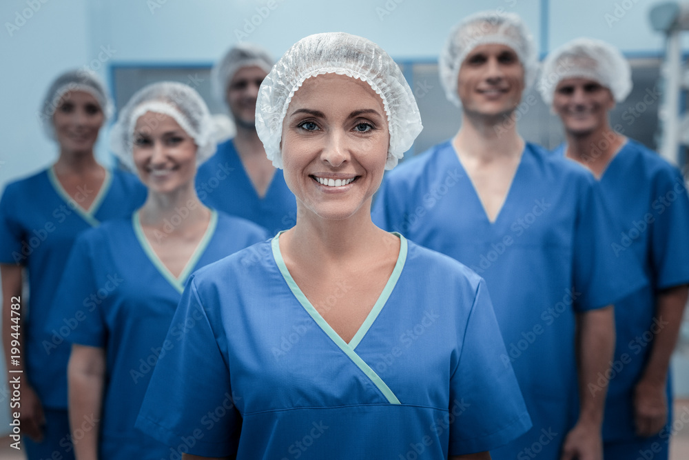 Medical team. Delighted nice female surgeon wearing uniform and ...