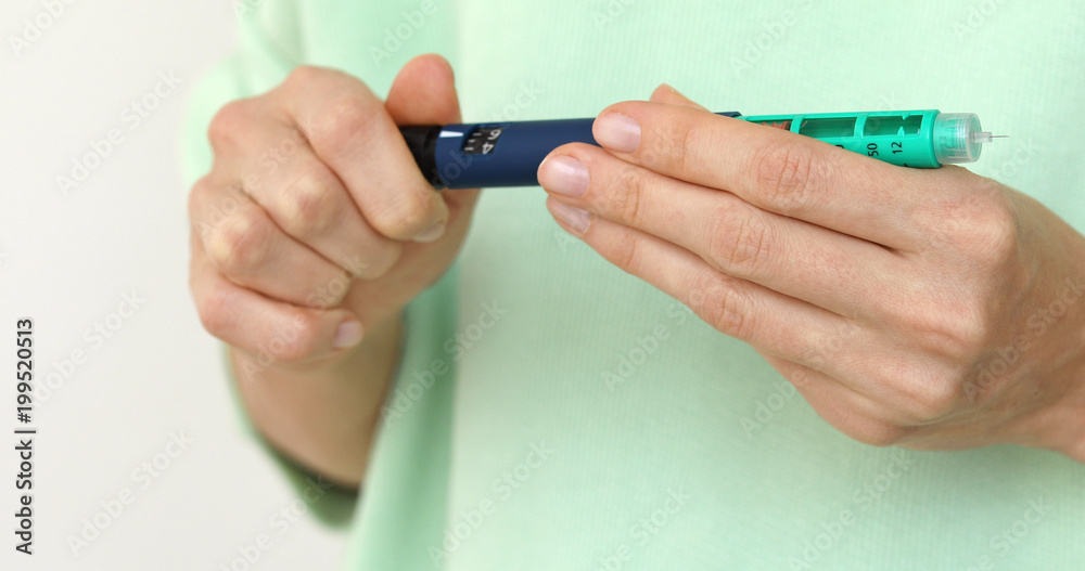 Diabetes patient turn knob on end of insulin pen and dial up correct ...