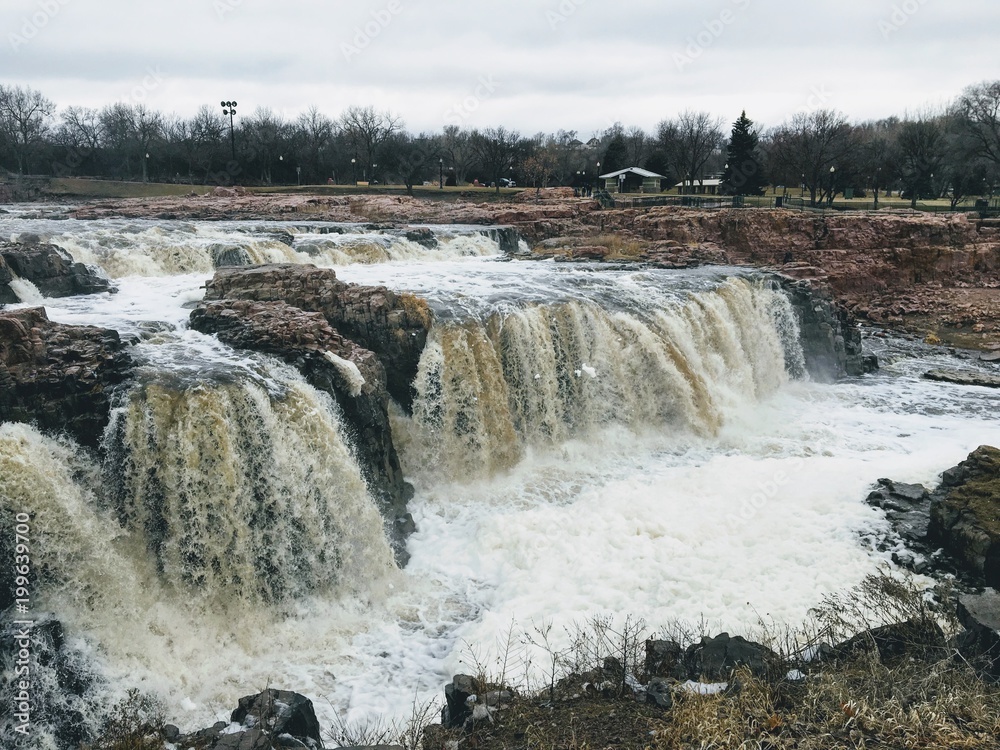 The Big Sioux River flows over rocks in Sioux Falls South Dakota with ...
