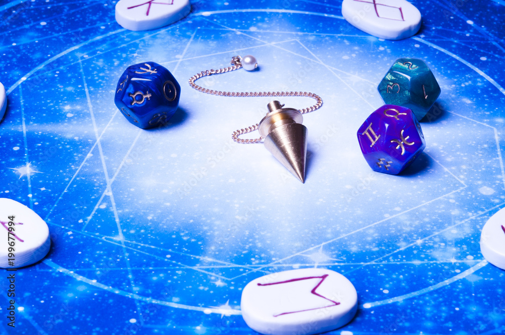 astrology dice, zodiac symbols on pendant, runes stones over blue ...