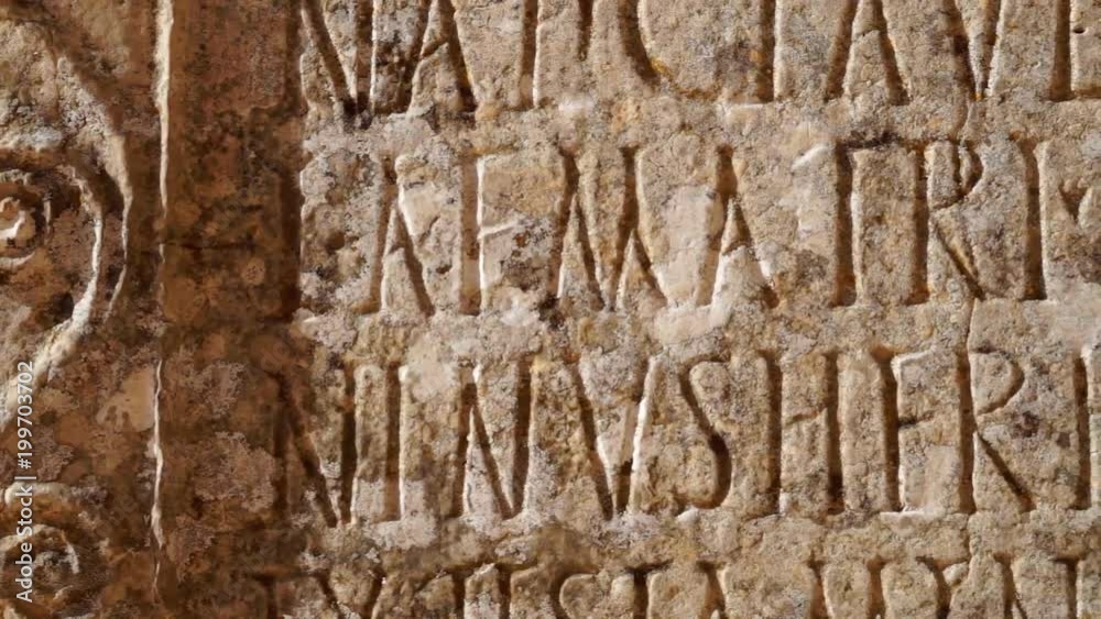 Tight shot of carved words in stone panel at ancient Roman ruins at the ...