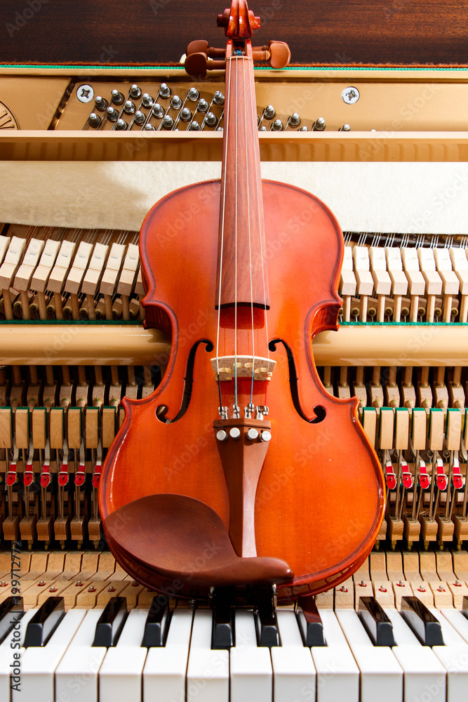 classic brown violin on the close up image of grand piano keys and ...