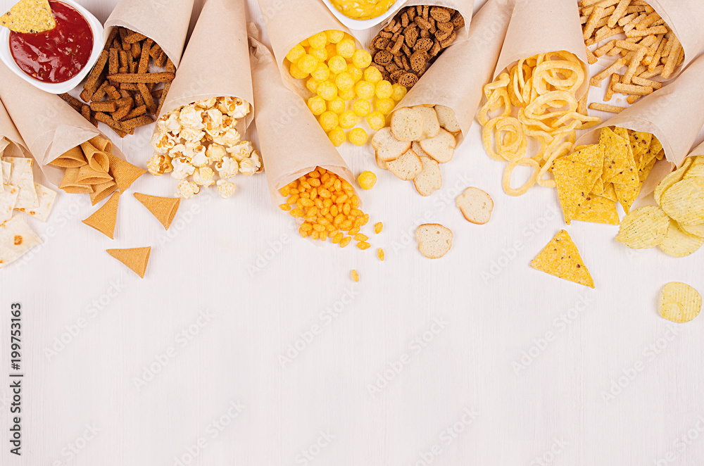 Summer fun fast food - different crunchy snacks in craft paper cone and ...