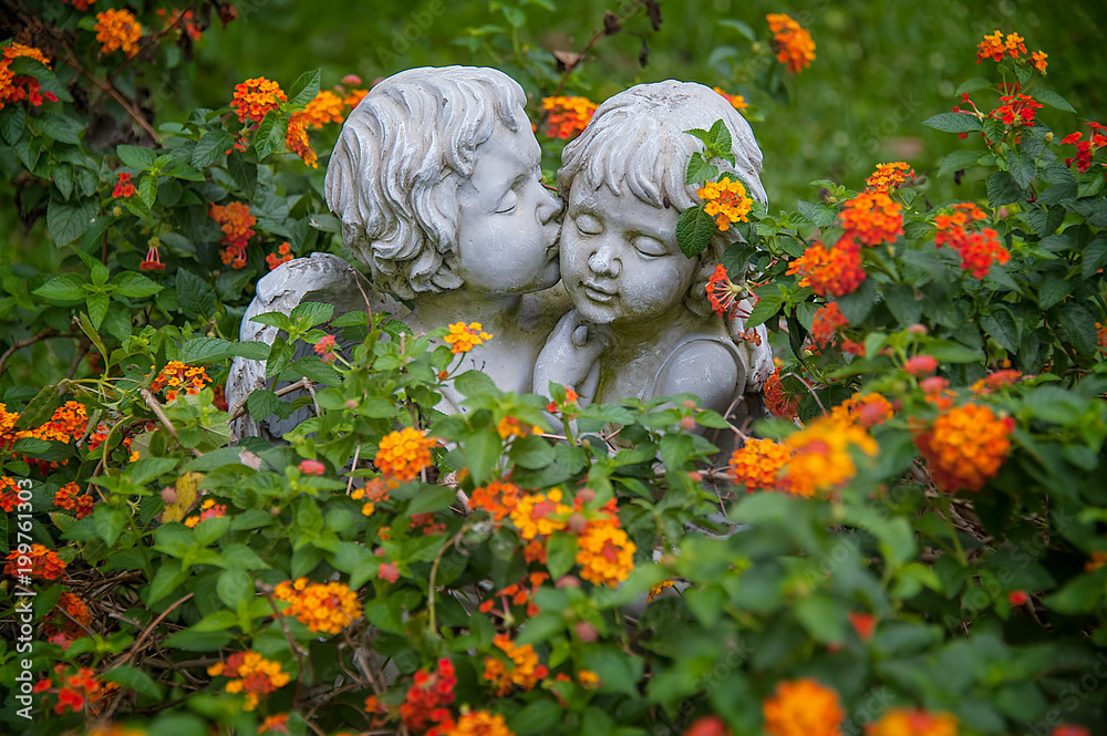 ANGELS IN LOVE. Sculptures of boy and girl angels surrounded with ...