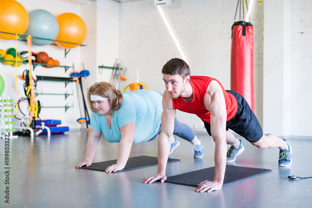 Full length portrait of overweight woman doing fitness exercises on ...