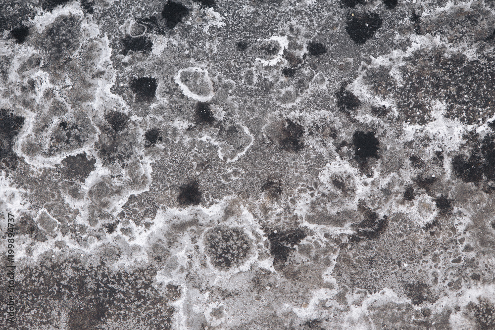 Road salt on asphalt parking lot in northern Illinois, in black and ...