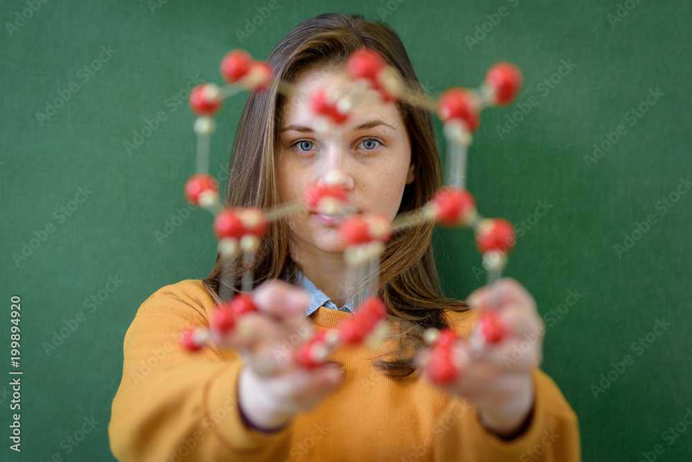 Female student holding molecular structure model. Science class concept ...