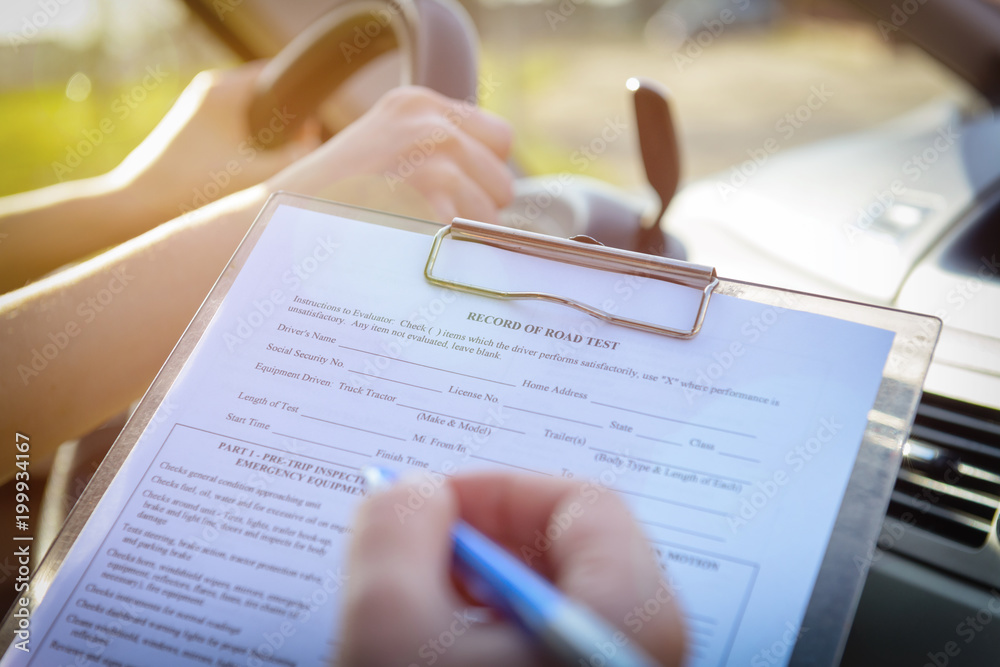 Examiner filling in driver's license road test form Stock Photo | Adobe ...