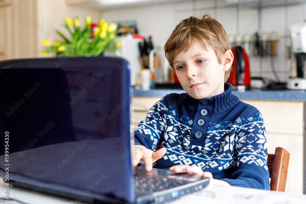 Little school kid boy making school homework on computer. Child having ...