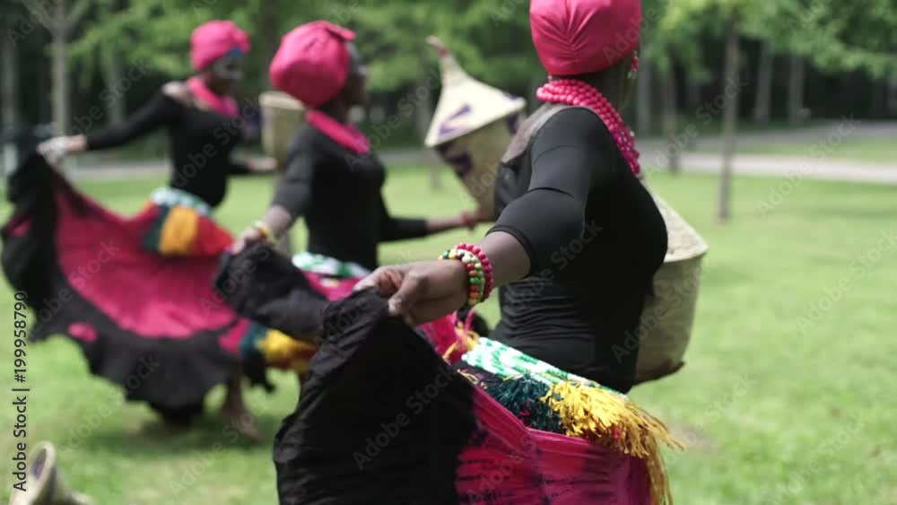 Three african women dancing folk dance in traditio.costumes with coats ...
