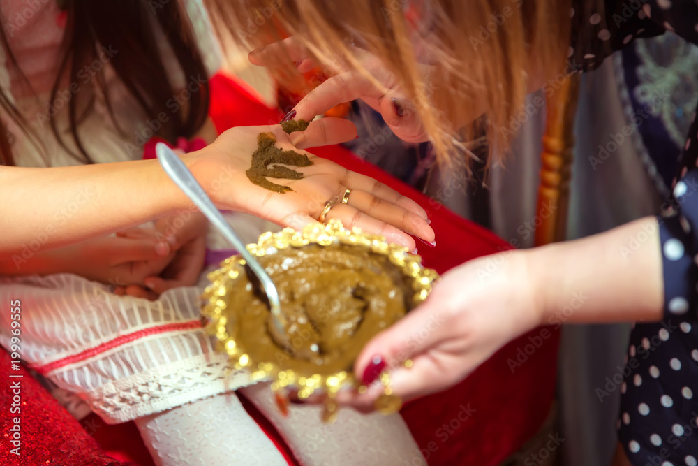 Female hands decoratively colored by henna with cup . Hold a bowl with ...