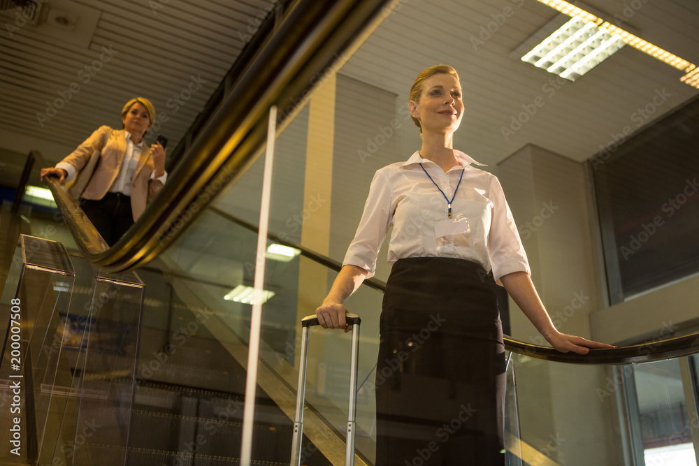 Female staff coming down from the escalator Stock Photo | Adobe Stock