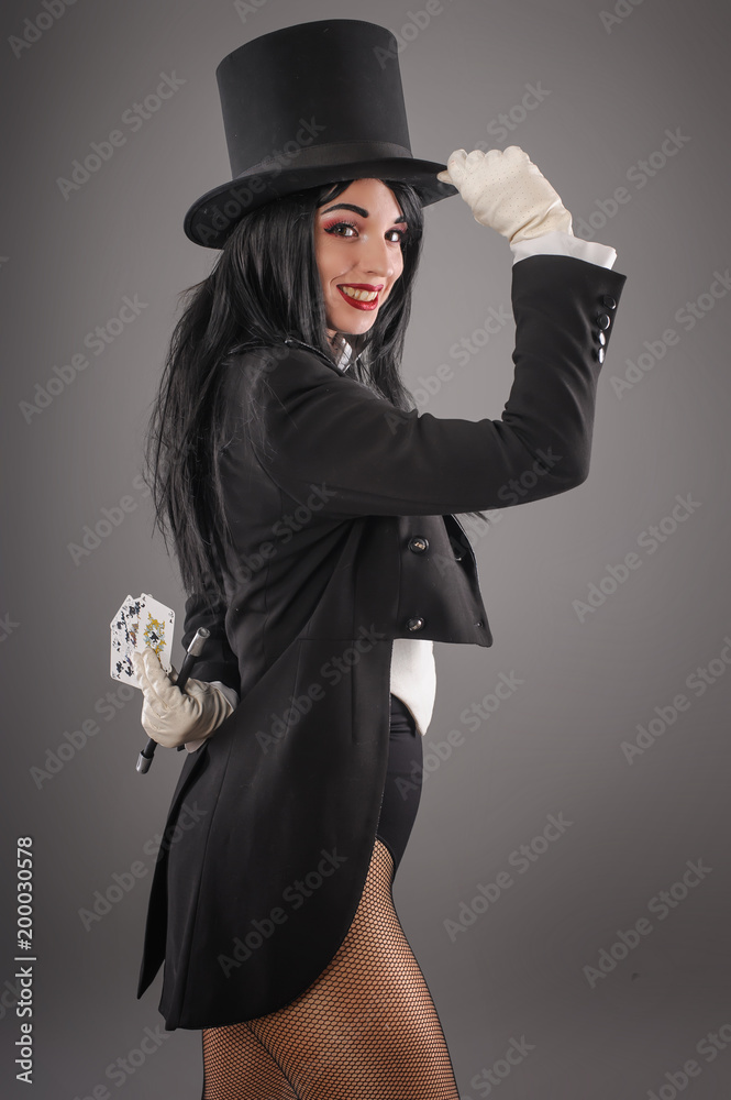 Female magician in performer suit with magic wand and playing cards ...
