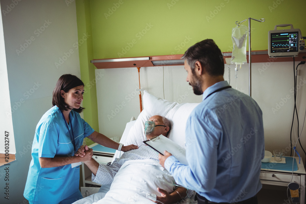 Nurse consoling senior patient with doctor Stock Photo | Adobe Stock