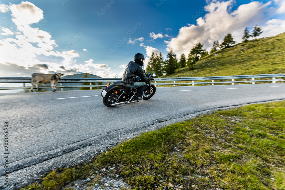Motorcycle driver riding in Alpine highway, Nockalmstrasse, Austria ...