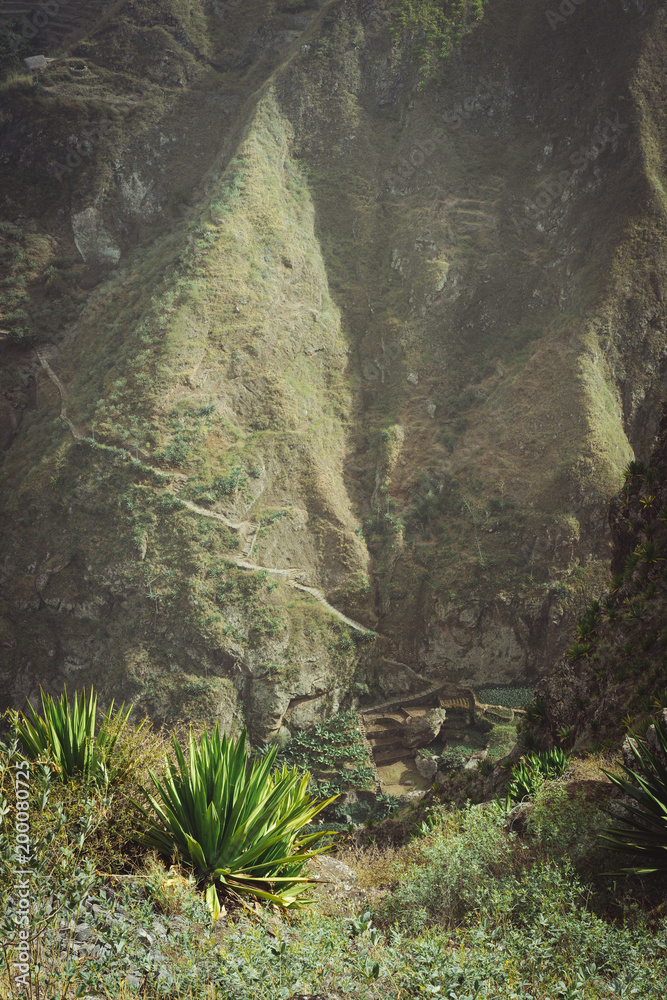 Incredible view of the steep mountain and path to green ravine. Huge ...