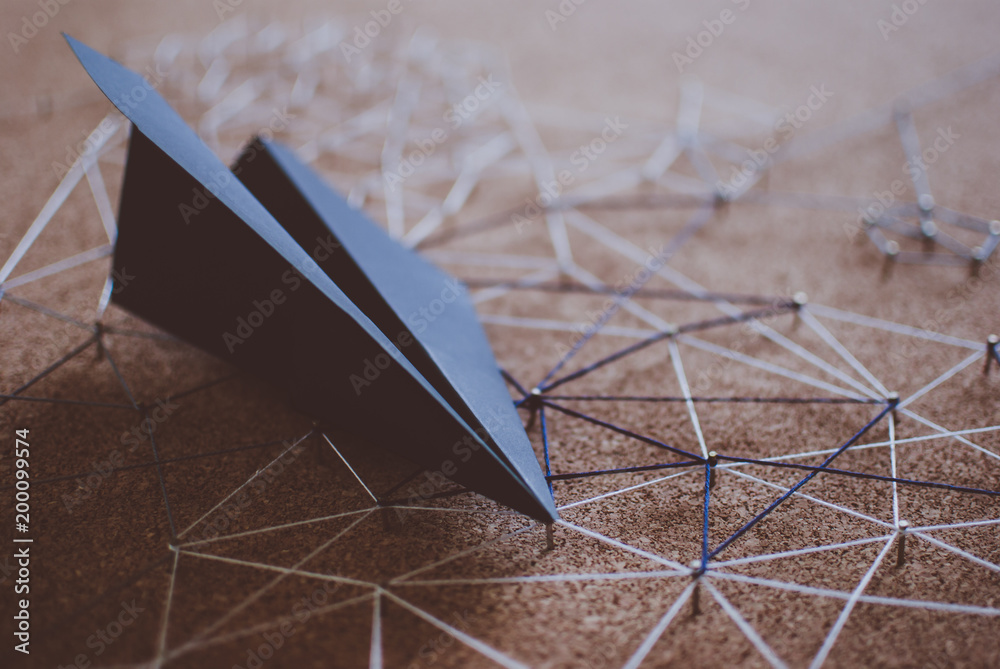 Black paper plane over the threads linking the nails. Entities ...