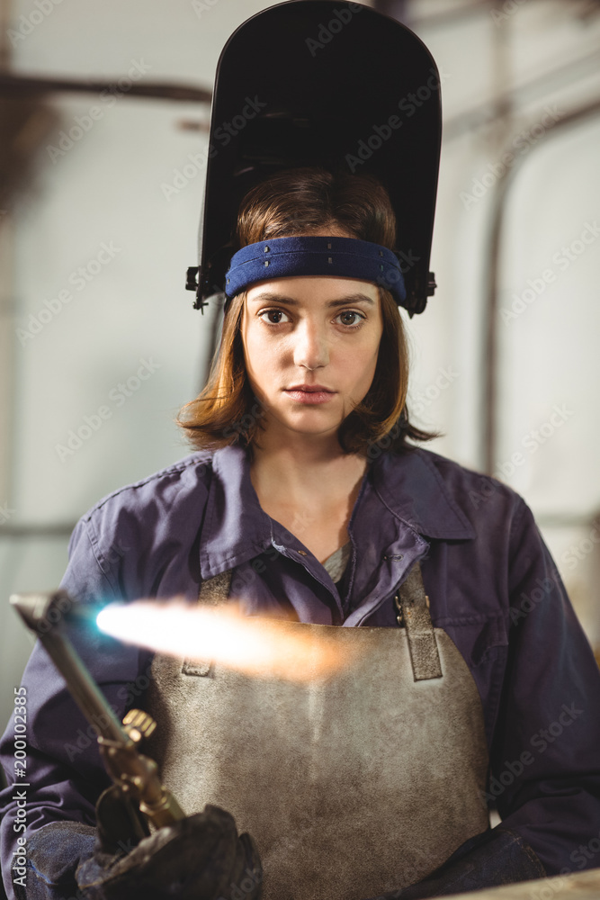 Female welder holding welding torch Stock Photo | Adobe Stock