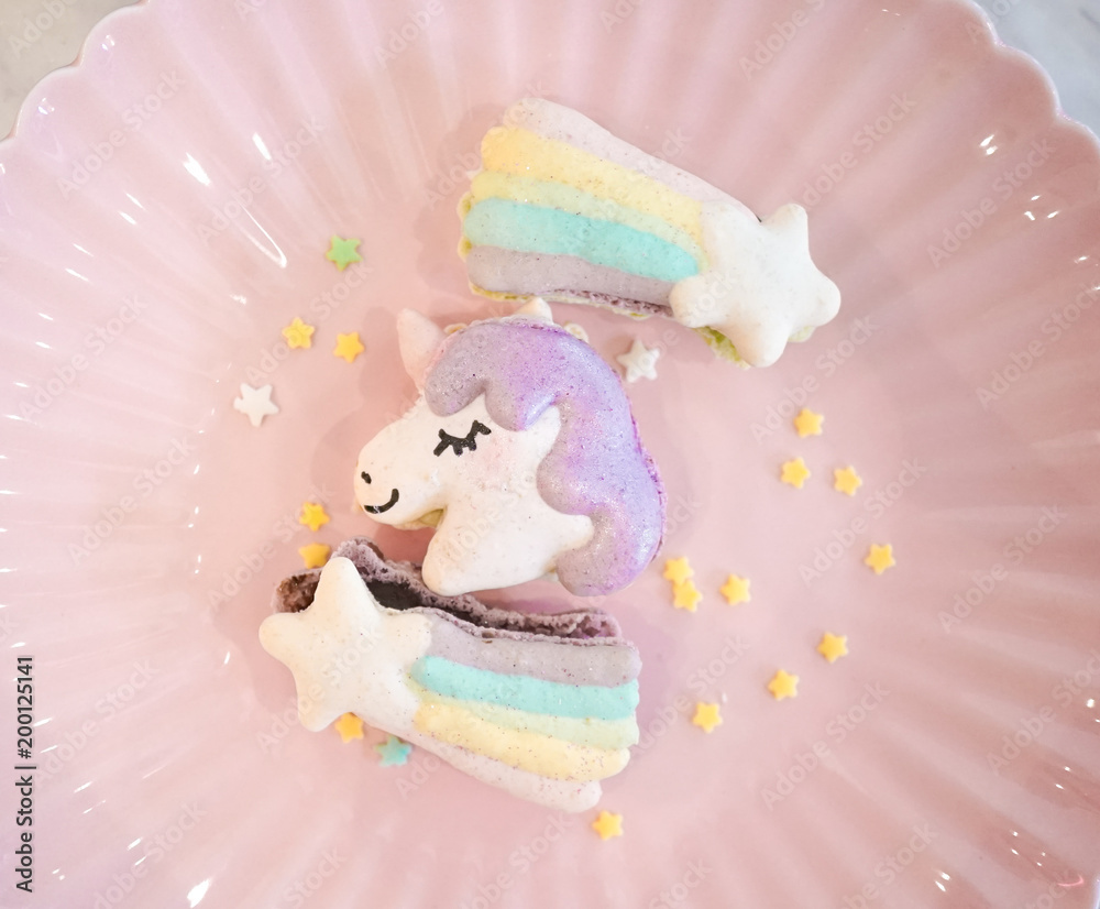 Unicorn macaron and pastel rainbow macarons on the pink dish with ...