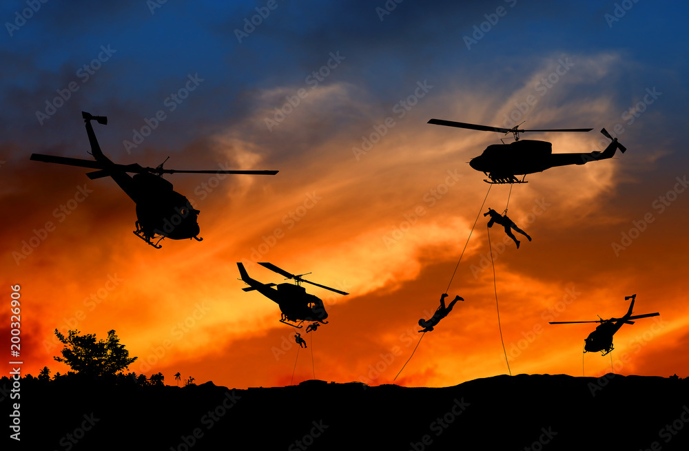 Silhouette Soldiers rappel down to attack from helicopter with sunset ...