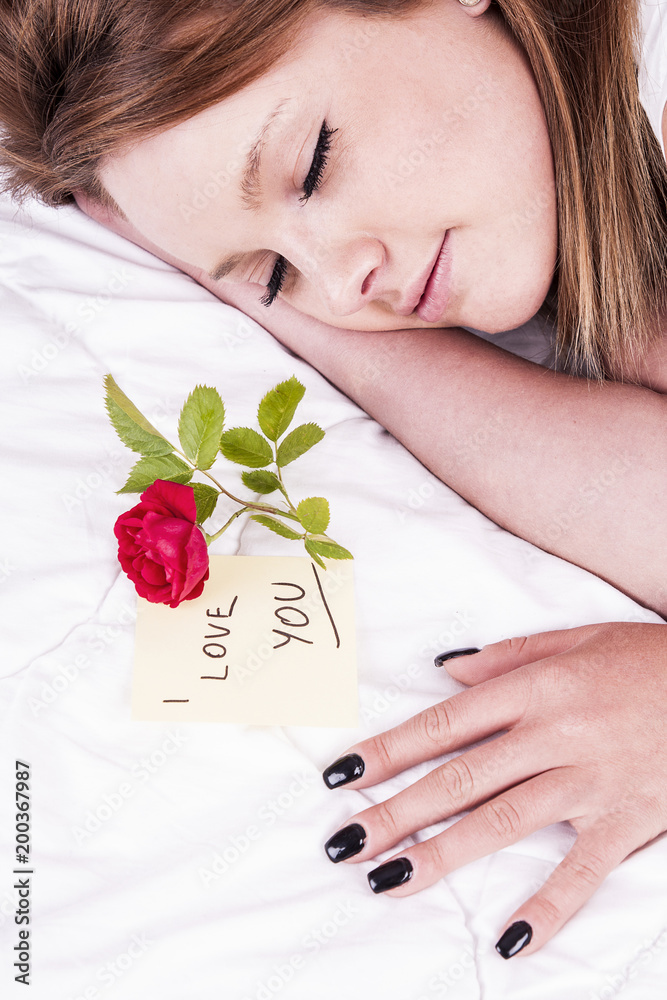 Beautiful woman sleeping near the rose flower and message on paper ...