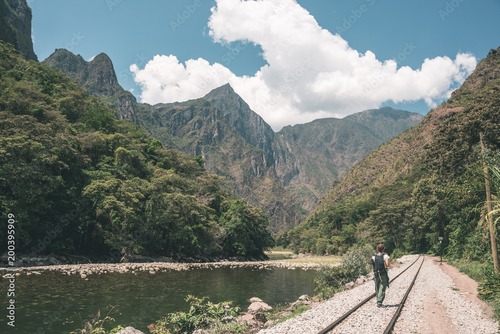 Backpacker walking on the railroad track to Machu Picchu, Peru ...