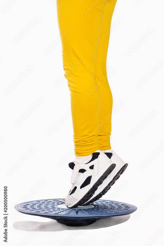 Little girl in on the tips of toes position staing on balance board ...