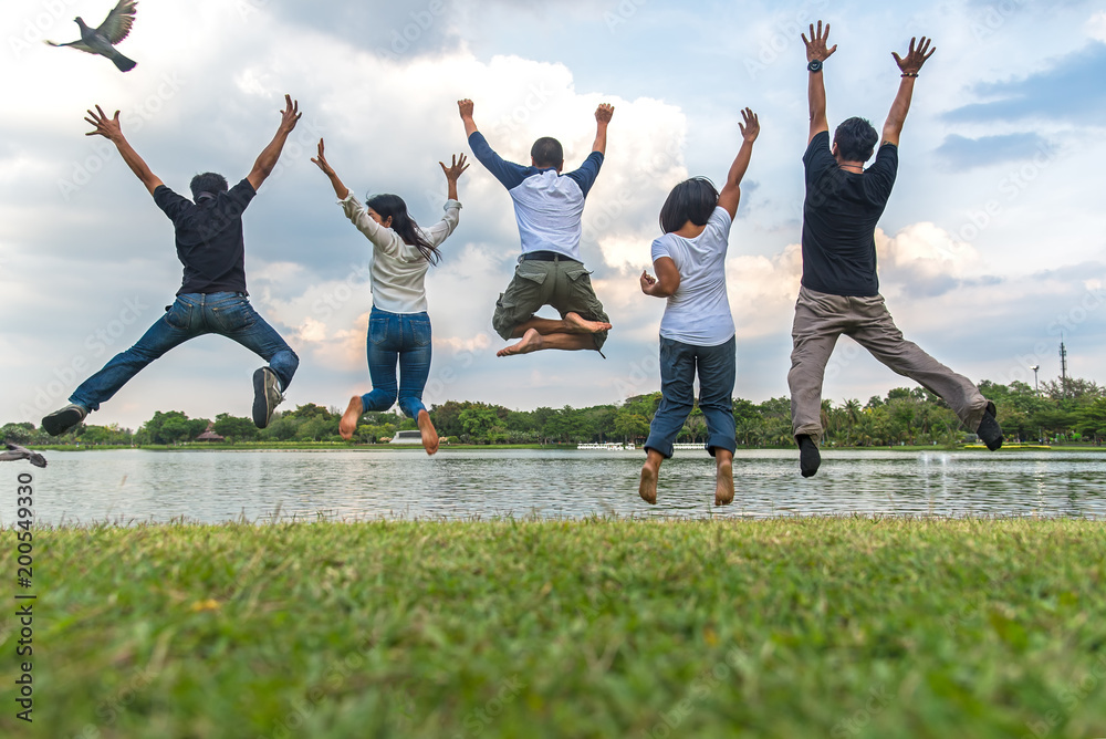 Teamwork success concept with group of jumping friends in the public ...