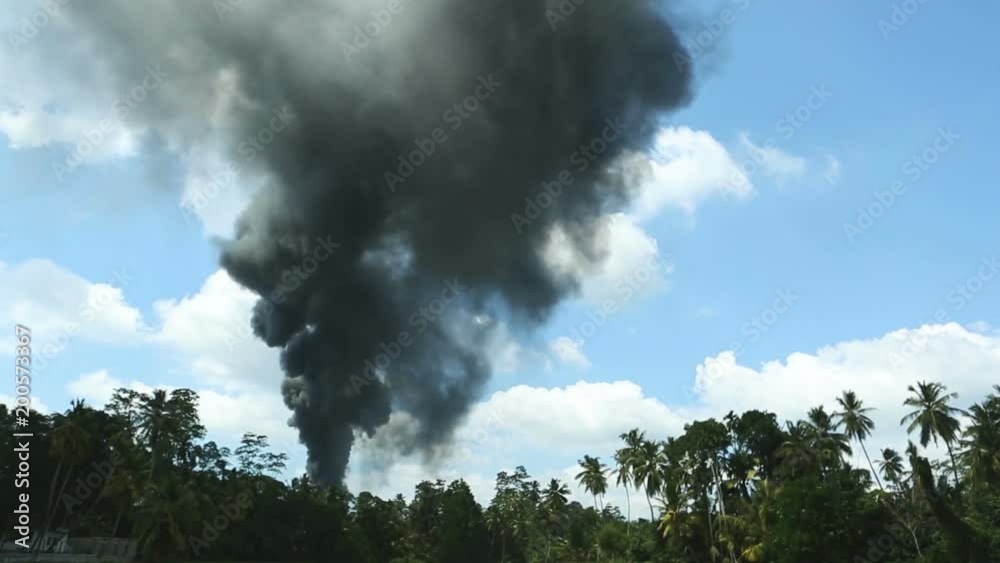 Wildfire. Fire in an Asian village. Black Smoke poured in the Tropical ...