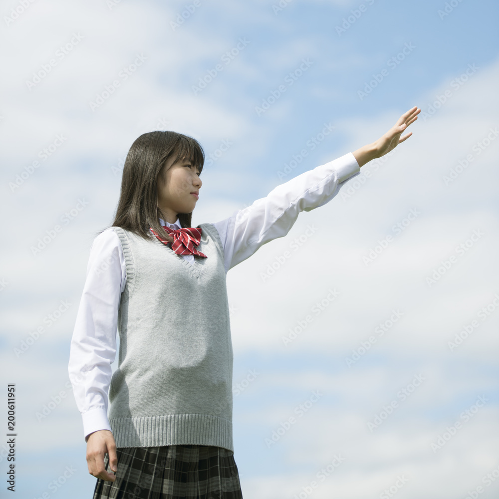 真剣な表情で手を伸ばす女子学生 Photos Adobe Stock