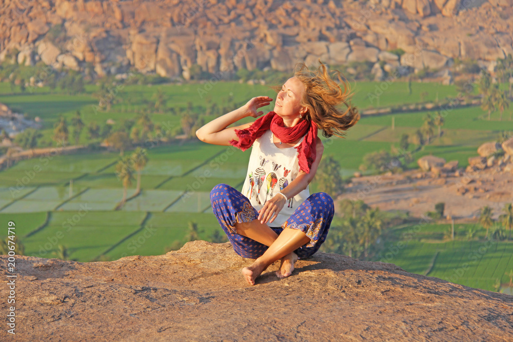 A girl in Hampi, sits and smiles on Anjaneya Hill, Hanuman Temple ...