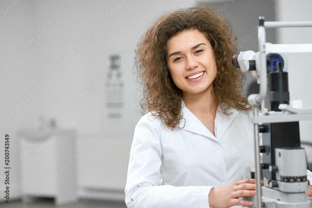 Young ophthalmologist standing near medical equipment for vision ...