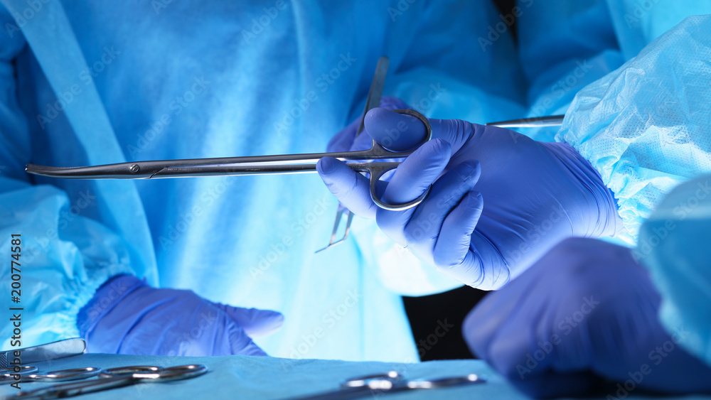 Surgeons hands holding surgical scissors and passing surgical equipment ...