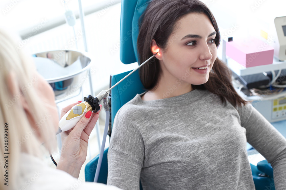 Otolaryngologist examining woman's ear with ENT telescope in hospital ...