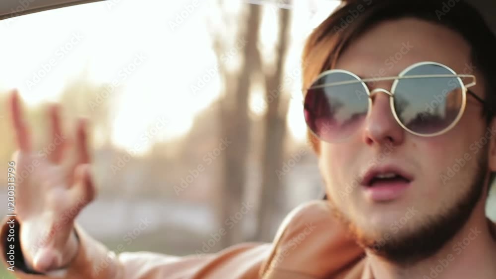 Blurred silhouette of a merry guy traveling by car. She reaches her arm ...