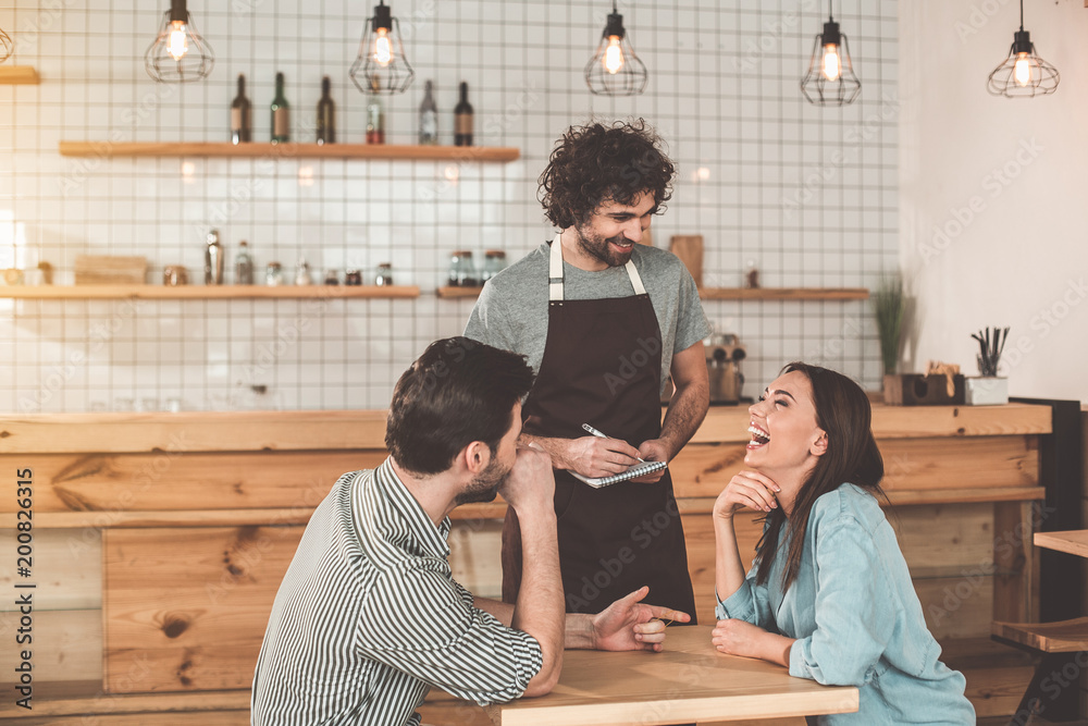 You choose. Joyful girl ordering food in cafeteria and laughing while ...