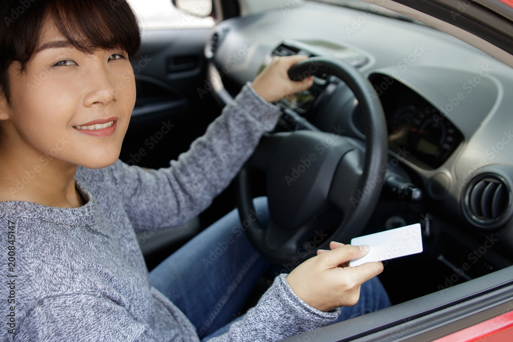 Attractive young asian woman proudly showing her drivers license ...
