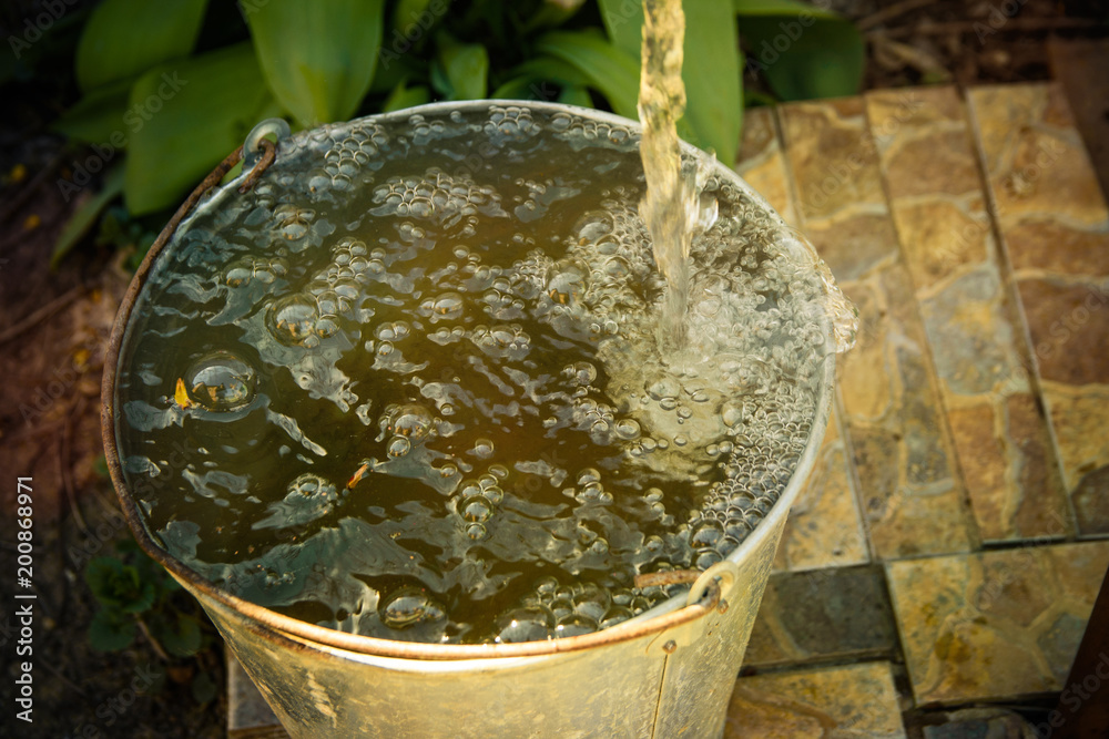 water flows into the bucket Stock Photo | Adobe Stock