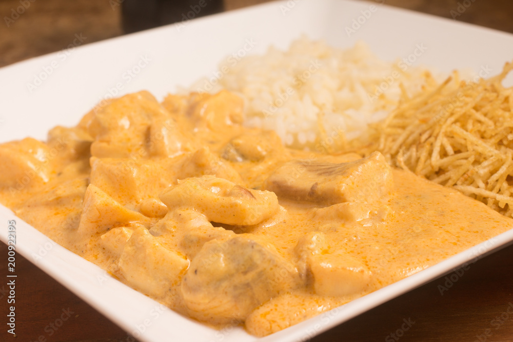 Tilapia. Fish fillet Stroganoff with potato sticks and rice Stock Photo ...