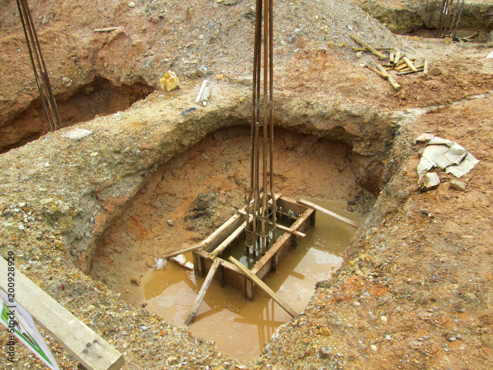 Construction workers fabricate pile cap form work with reinforcement ...