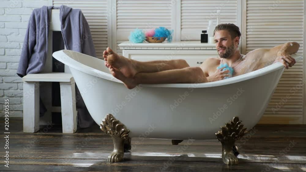 Young handsome man relaxing in the tub. Man with beard having a bath in ...