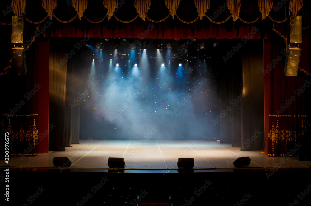 An empty stage of the theater, lit by spotlights and smoke before the ...