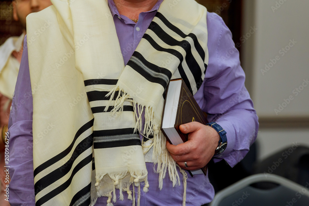 Hands holding a jewish prayer book wearing a prayer shawl Stock Photo ...