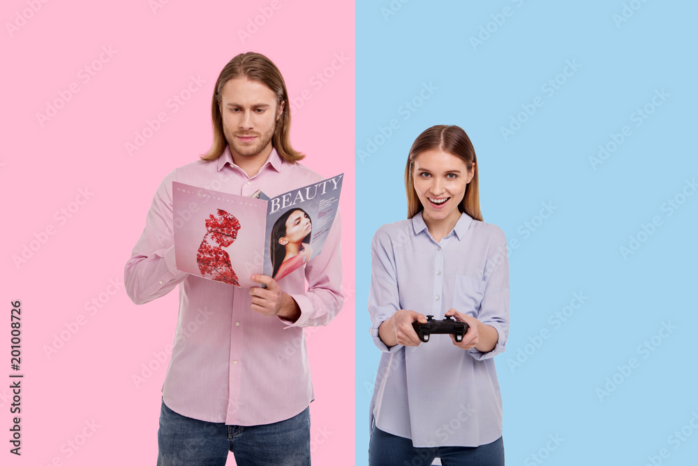 Switch of roles. Charming young woman playing a video game with a ...