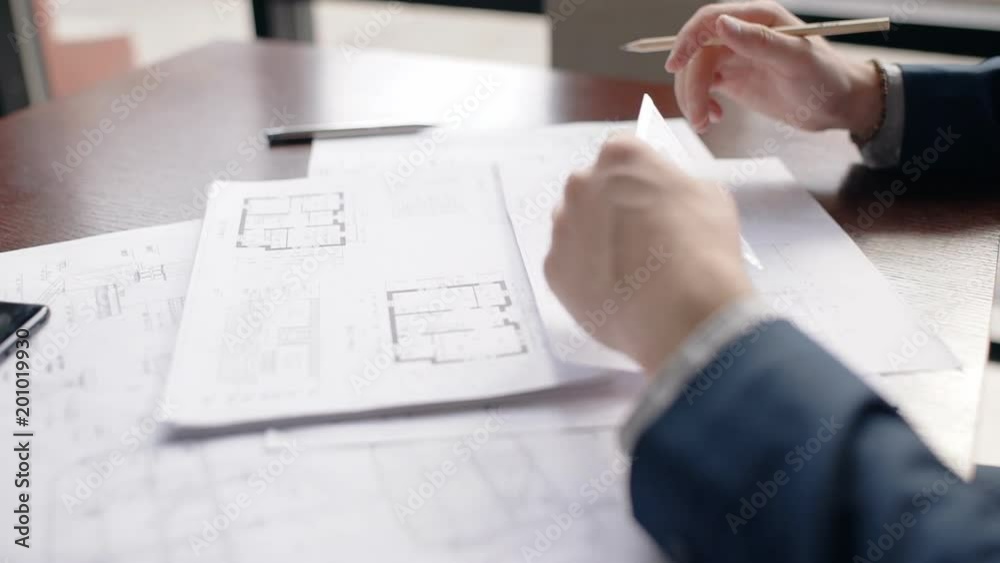 Close up hands of male architect making hause blueprint in office ...