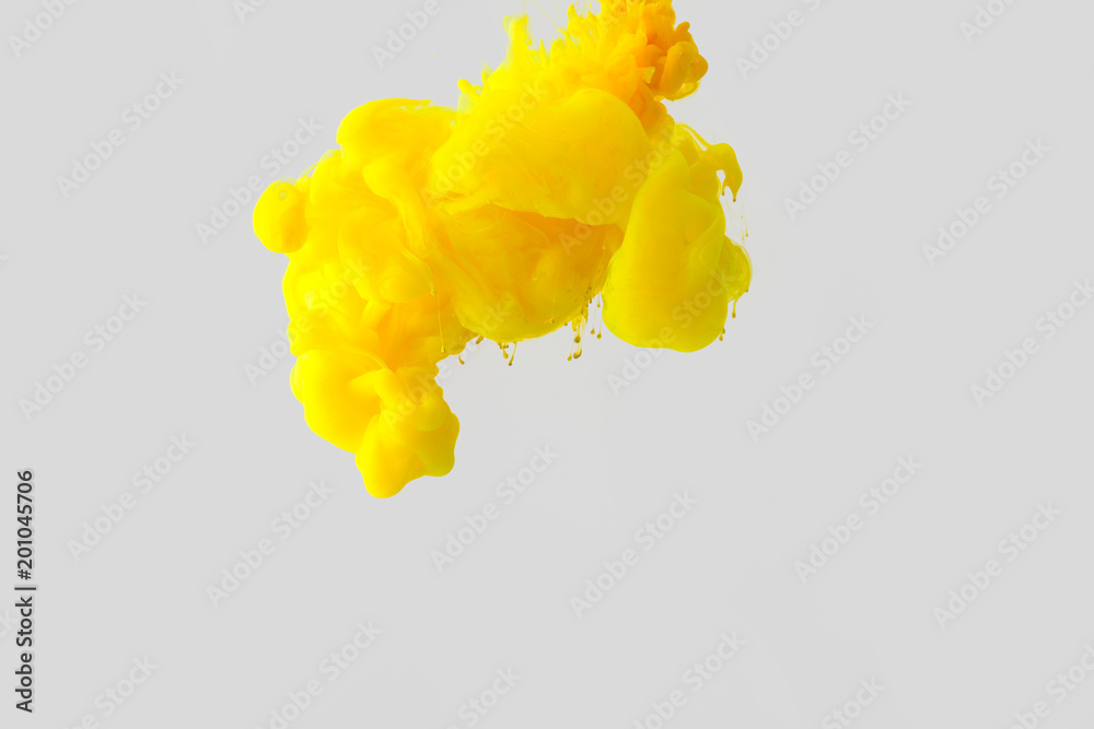 close up view of bright yellow paint splash in water isolated on gray ...