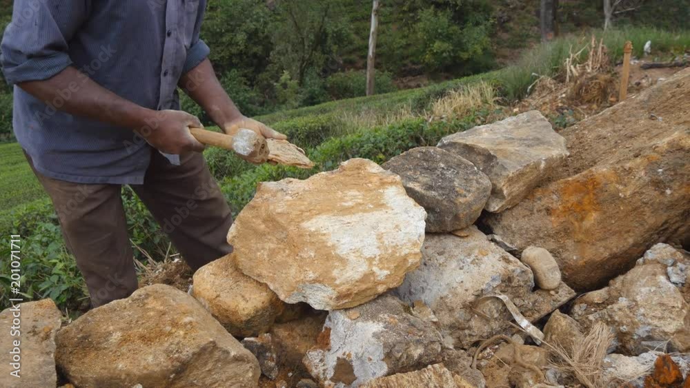 Close up of unrecognizable indian man cutting a block of granite with ...
