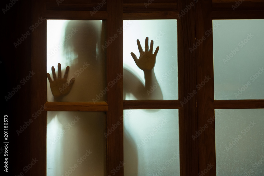 Horror woman behind the window glass in black and white. Blurry hand ...